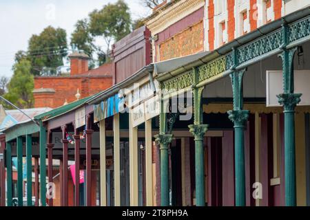Wrought iron and ornate veranda posts in front of old buildings facades ...