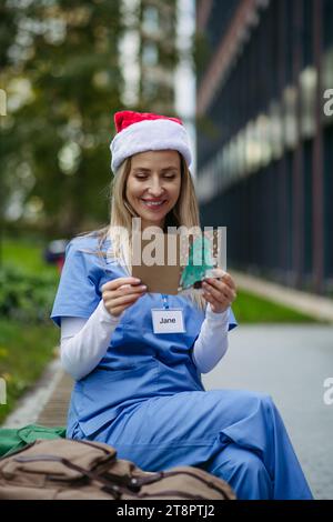 Nurse reading christmas card from child patient. Working in hospital on ...