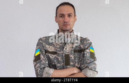 Portrait of a courageous Ukrainian military man holding the flag of ...