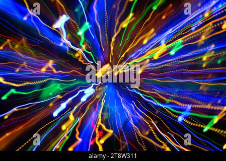 Blurred multi coloured light patterns streaks against a dark background ...