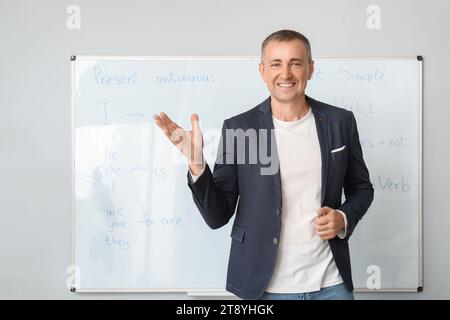 Male teacher conducting English grammar lesson in classroom Stock Photo ...