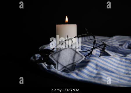 Prisoner uniform, Jewish badge and barbed wire on dark background ...