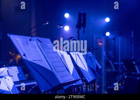 music stands with orchestral notes. Dim stage of the concert hall ...