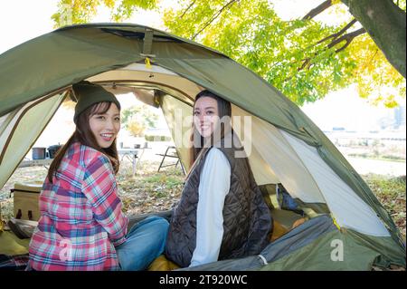 Two women enjoying camping Stock Photo - Alamy