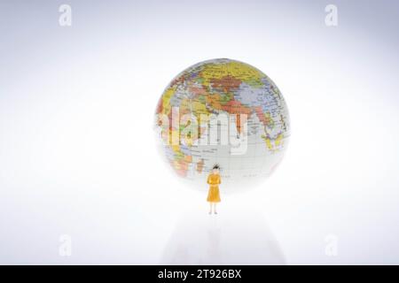 ittle model globe by the side of man figure Stock Photo - Alamy