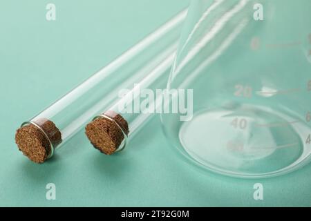 Flask and test tubes on turquoise background. Laboratory glassware ...