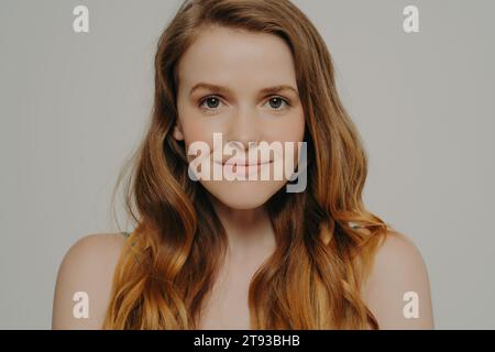 A Caucasian woman with a subtle smile looks off to the side, with copy ...