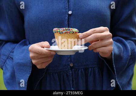 Woman with delicious edible biscuit cup of coffee decorated with ...