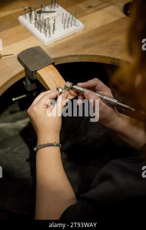 Hand of female goldsmith working with grinder on silver ring Stock ...