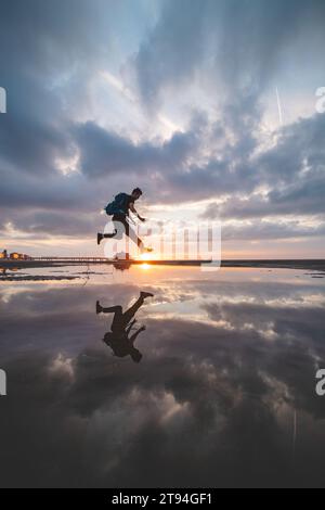 Silhouette of tourists enjoying the beach during a beautiful sunset ...