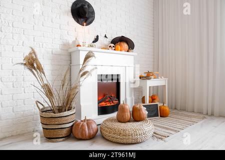 White fireplace with Halloween pumpkins and decorations near green wall ...
