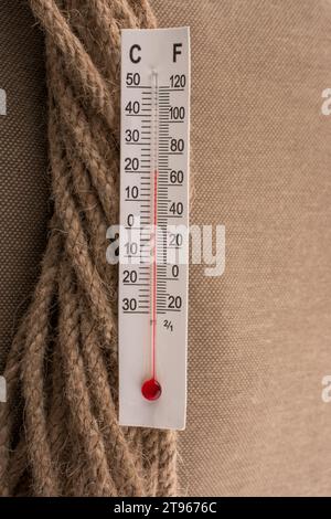 Thermometer placed on a brown rope on a fabric background Stock Photo ...