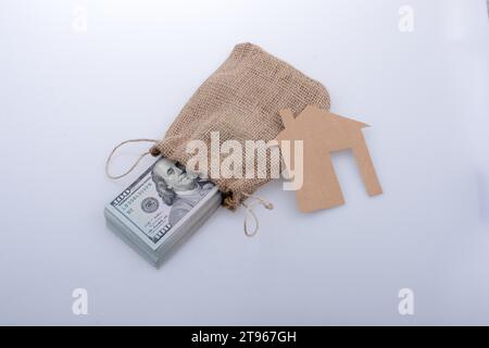 Paper house placed beside a bundle of US dollar banknote Stock Photo ...
