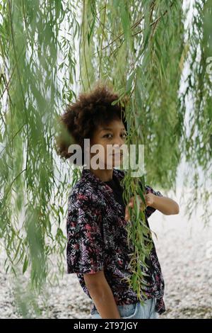 Smiling young woman standing amidst olive trees at farm Stock Photo - Alamy