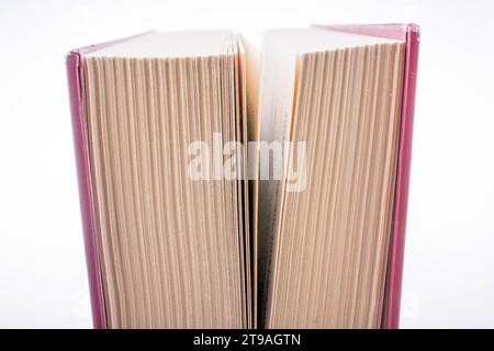 Book pages partly in view on white background Stock Photo - Alamy