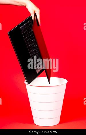 Black laptop in a trash bin on a red background isolated Stock Photo ...