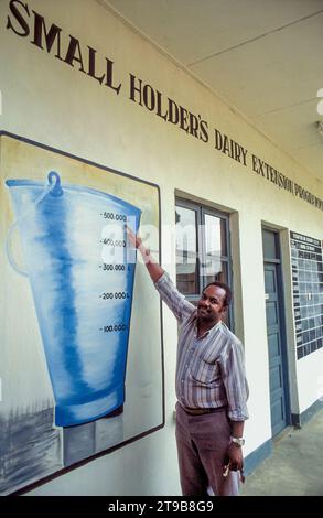Tanzania, Tanga - Man pointing at mural showing target amount of milk ...