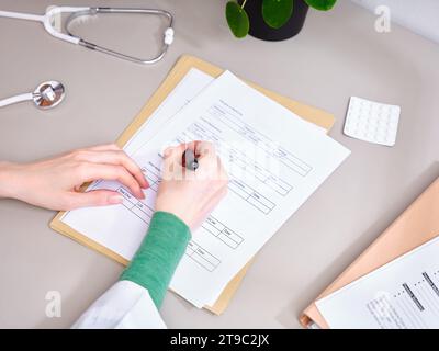 Top view unrecognisable doctor taking notes in medical documentation at ...