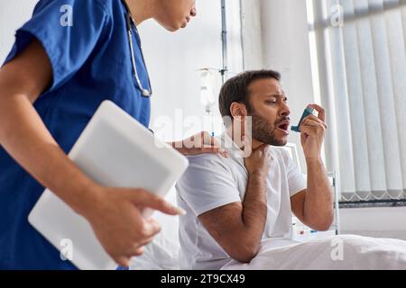 african american nurse helping her indian patient with asthma inhaler ...