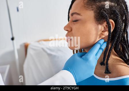 young indian doctor examining lymph nodes of his ill african american ...