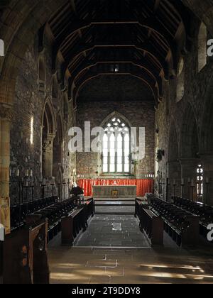 nave & wooden pews of Iona Abbey with light flooding through arched ...