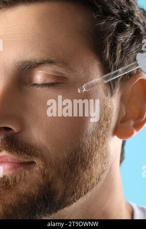 Handsome man applying moisturizing serum on face Stock Photo - Alamy