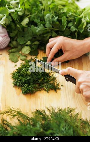 Female hands chopping dill on wooden board, close-up, isolated on white ...