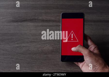 Smartphone with triangle caution warning icon. Copy space for text ...