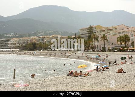 Menton, France - June 18, 2019: People rest on the beach of the Menton ...