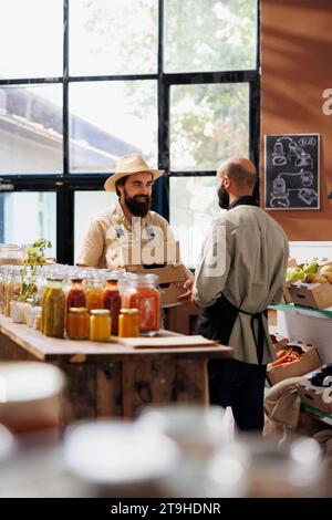 A shopkeeper & customer talking in a local shop with glass milk bottles ...