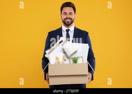 Happy unemployed man with box of personal office belongings showing ...
