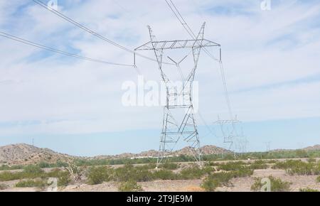 Large tall power lines running through desert landscape with mountains ...