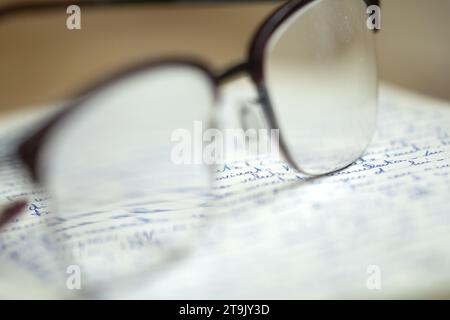 handwritten sheet with the writing seen through a pair of glasses Stock ...
