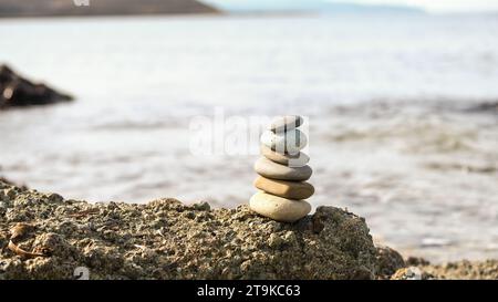 Stone cairn pyramid at seaside. Stack of balanced stones on the beach ...