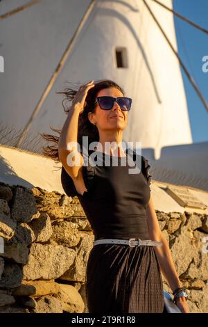 Photo of young joyful woman wearing wrist watch using cellphone and ...