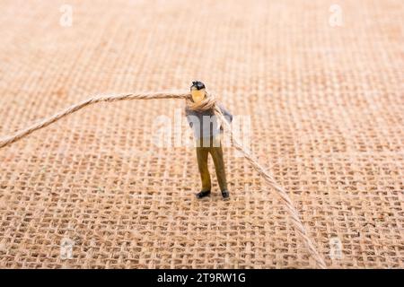 Figurine man with a rope on the neck Stock Photo - Alamy