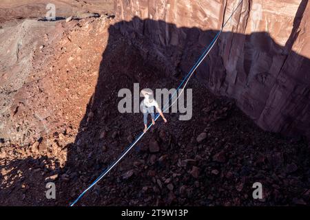 Aerial view of a young man highlining 500 feet above the canyon floor ...