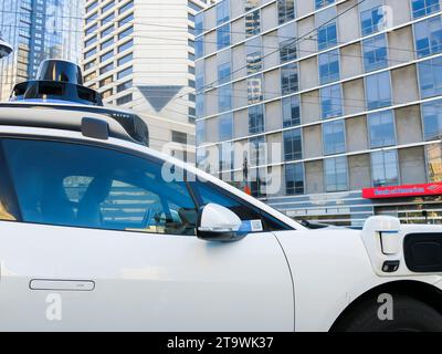 Self-driving Waymo vehicle at city intersection in front of Uber ...