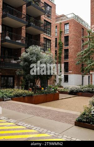 Modern apartment building with balconies and greenery. The structure features a glass wall and ...