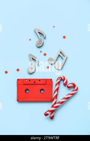 Music notes with audio cassette and Christmas decor on blue background ...