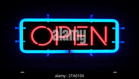 flickering blinking red and blue neon sign on brick wall background ...