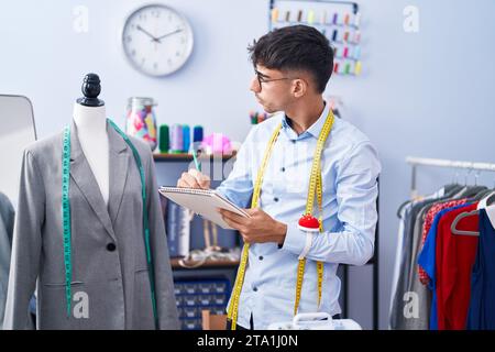 Young hispanic man tailor drawing on touchpad at tailor shop Stock ...