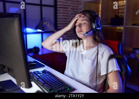 Young caucasian woman streamer stressed using computer at gaming room ...