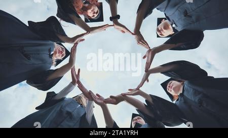 College graduates make a circle of their hands Stock Photo - Alamy