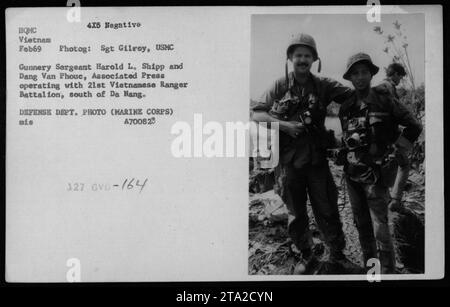 Associated Press photographer Dang Van Phuoc, center, is helped by ...
