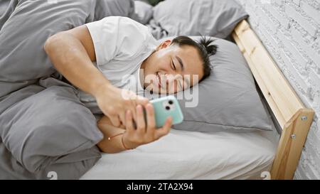 Cheery online morning. A handsome young man working on his laptop ...