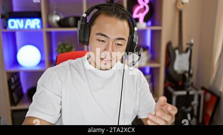 Young chinese man streamer playing video game using computer at gaming ...