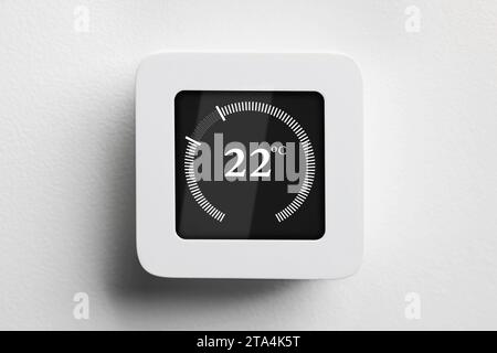 Thermostat displaying temperature in Celsius scale and different icons. Smart home device on ...