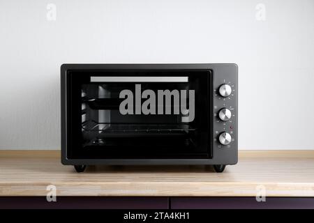 One electric oven on wooden table against white background Stock Photo ...