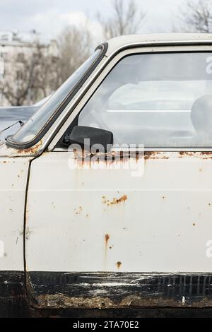 Sheet metal corrosion over wheel of old white car. Rusty messy surface ...